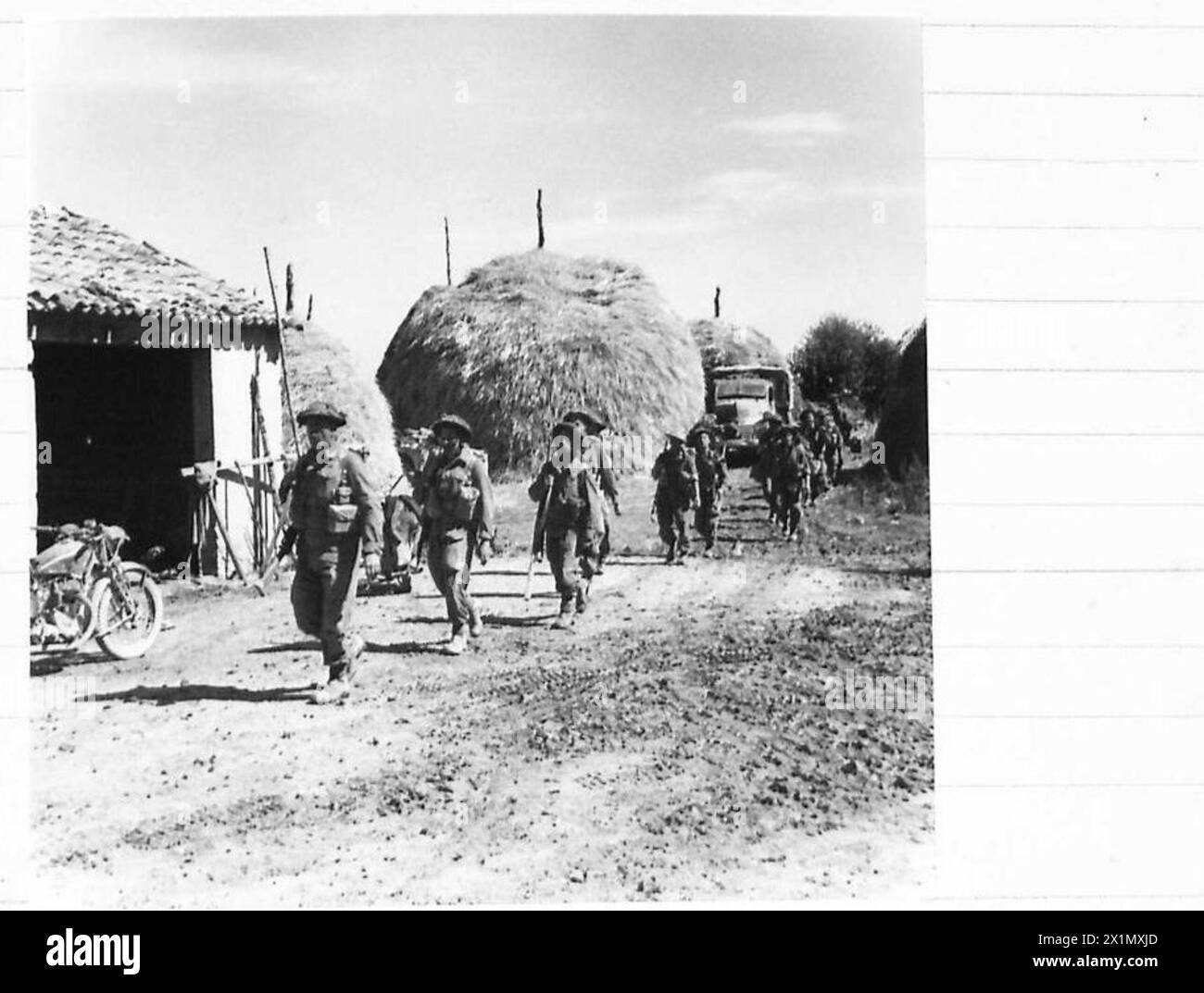 Infantrymen of the 1st Battalion Welch Regiment advance through a farm ...