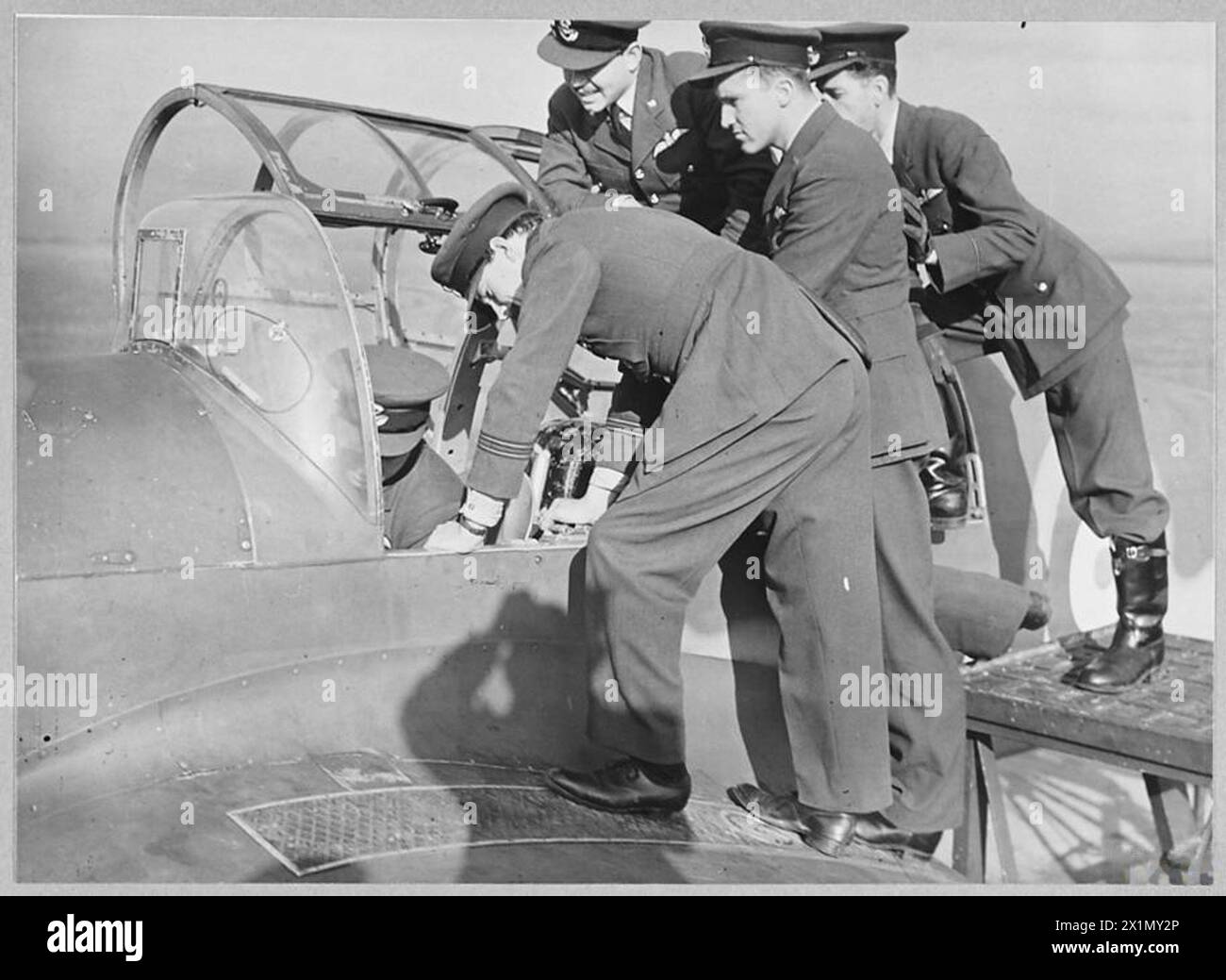 American pilots of the Eagle Squadron examine cockpit controls ...