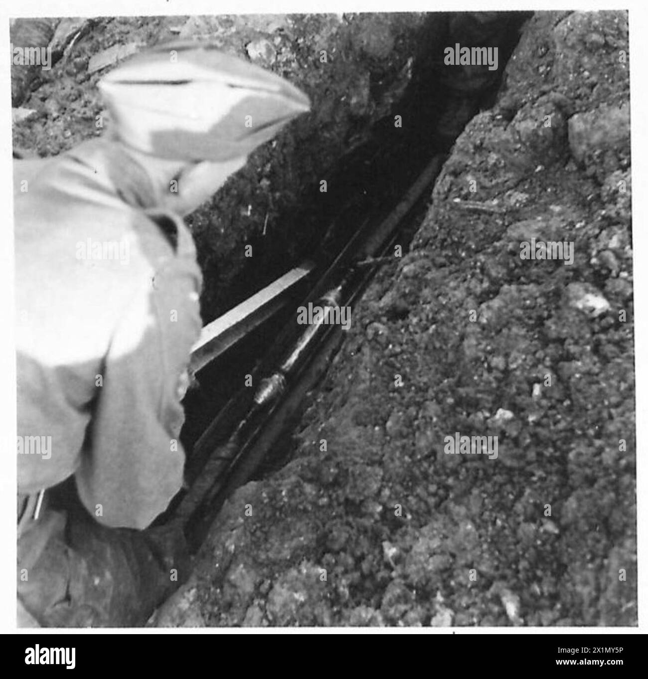 A lineman fixes the lid of a lead box containing a signal joint at the ...