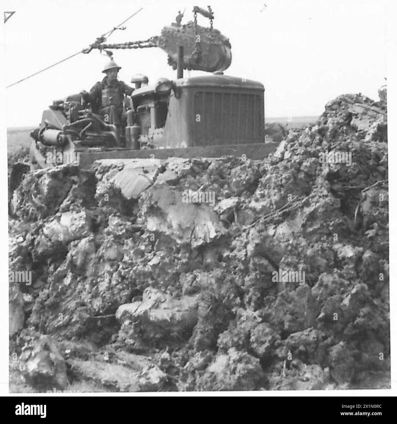 A bulldozer is used by the British Army to dispose of earth removed by ...