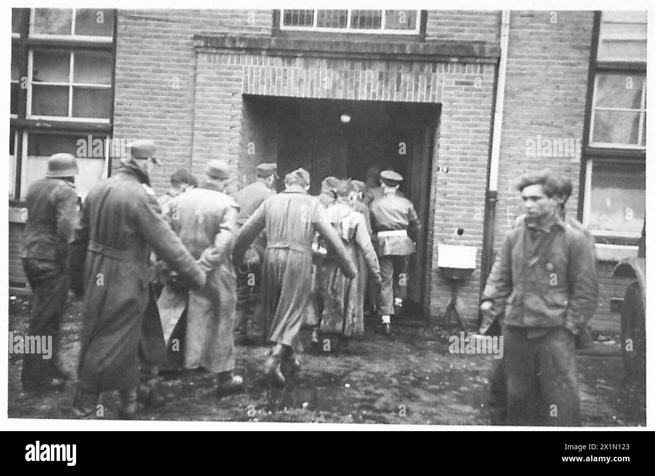 Prisoners of war are marched into a building under British Army ...