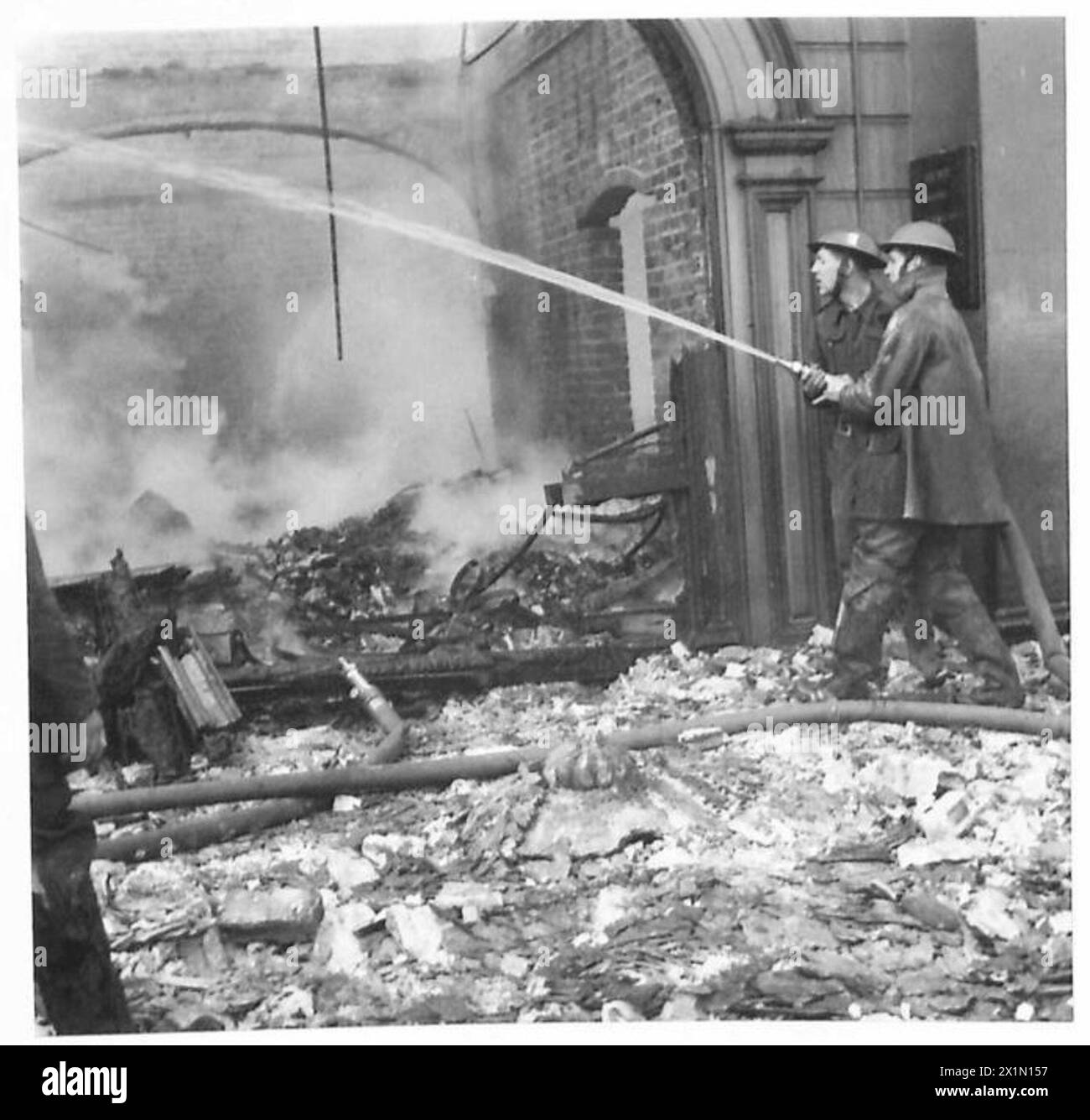 BOMB DAMAGE IN BELFAST - Firemen at work on one of the fires, British ...