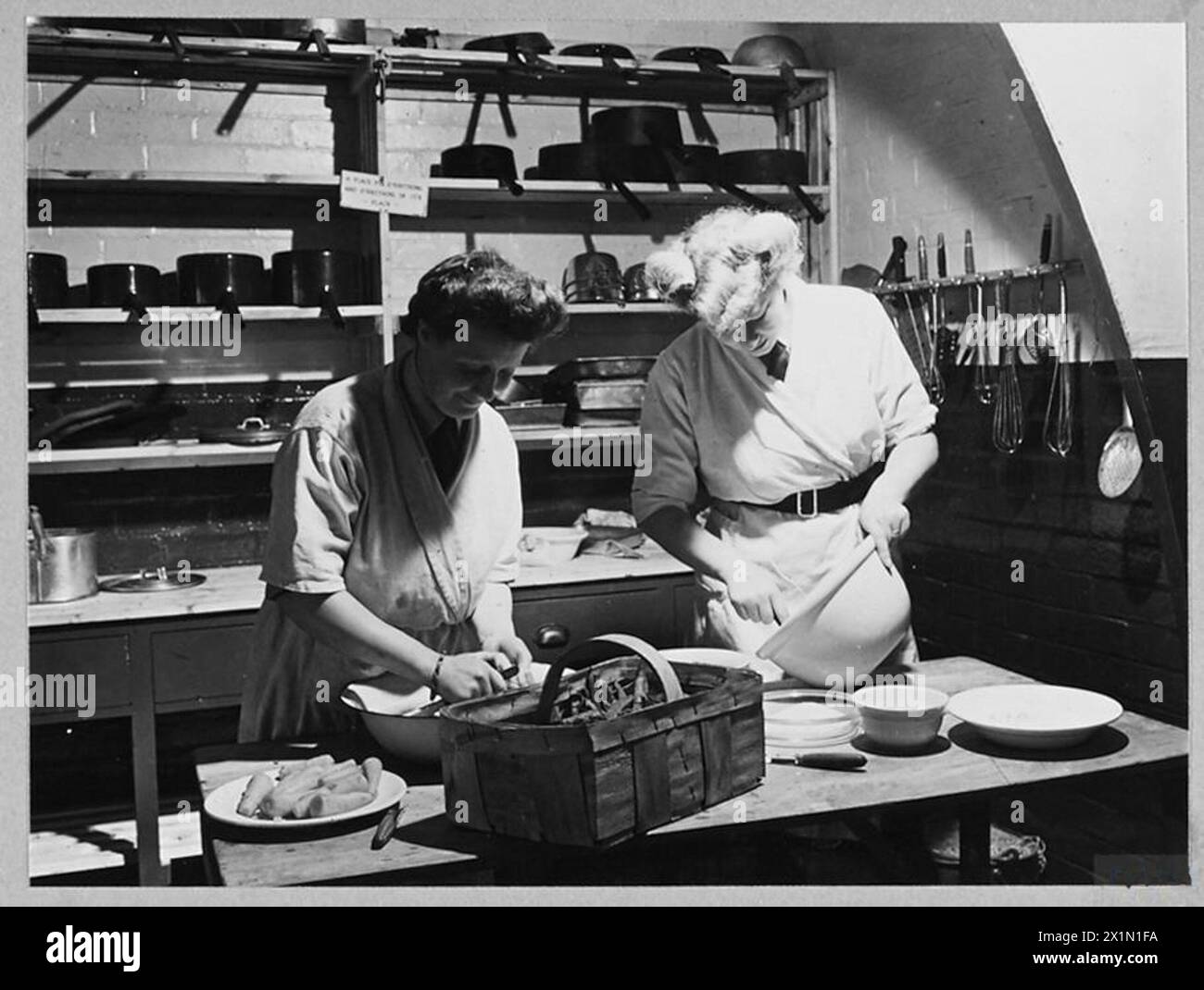 Leading Aircraftwomen A. Burr and Morgan prepare breakfast during the ...