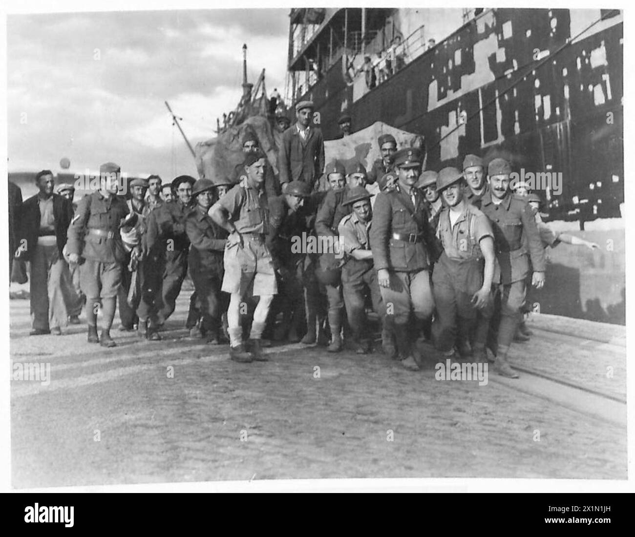 British and Greek soldiers move a large artillery gun from a jetty upon ...