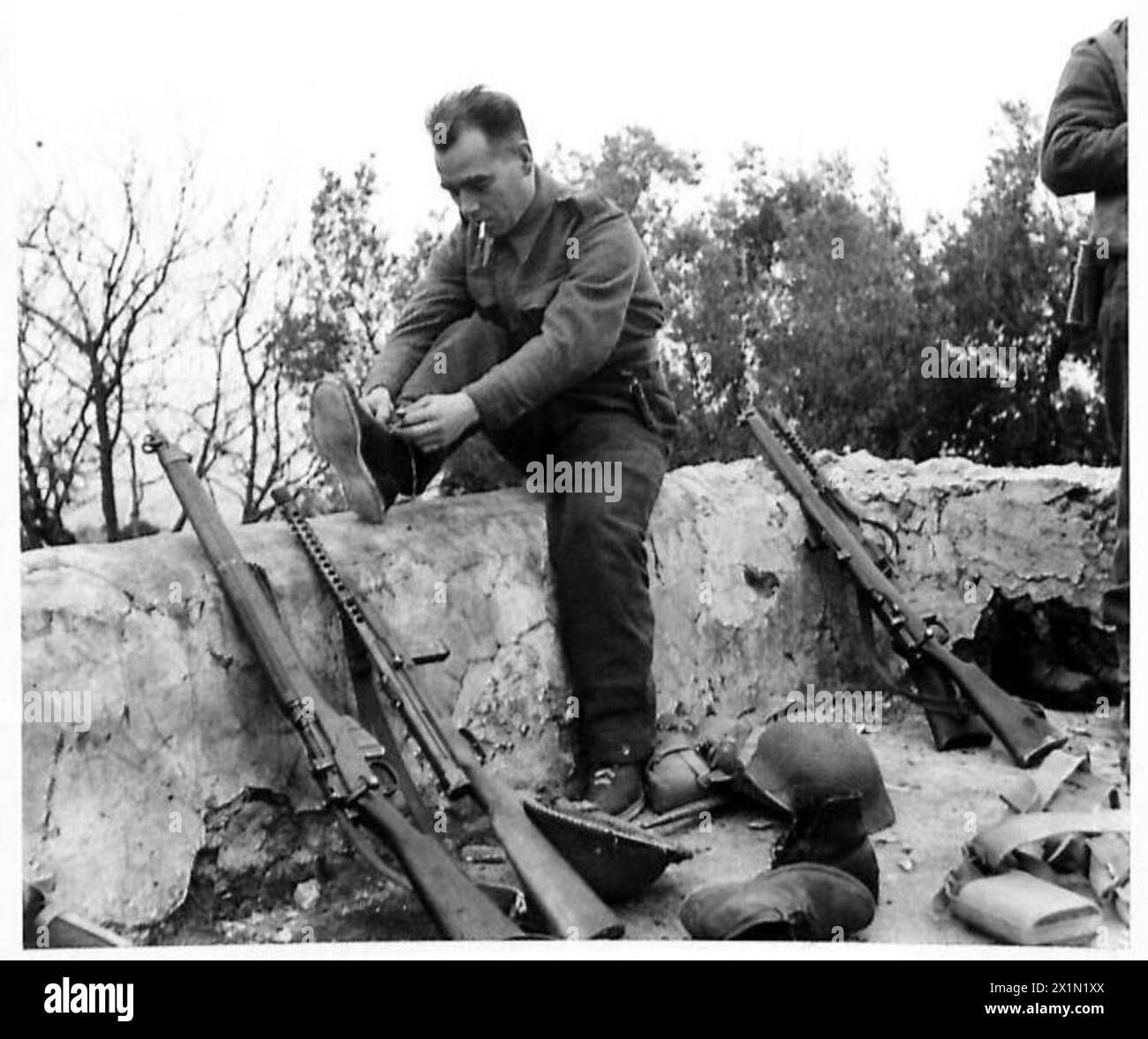 Fusilier J. Richardson prepares for a battle patrol by lacing his boots ...
