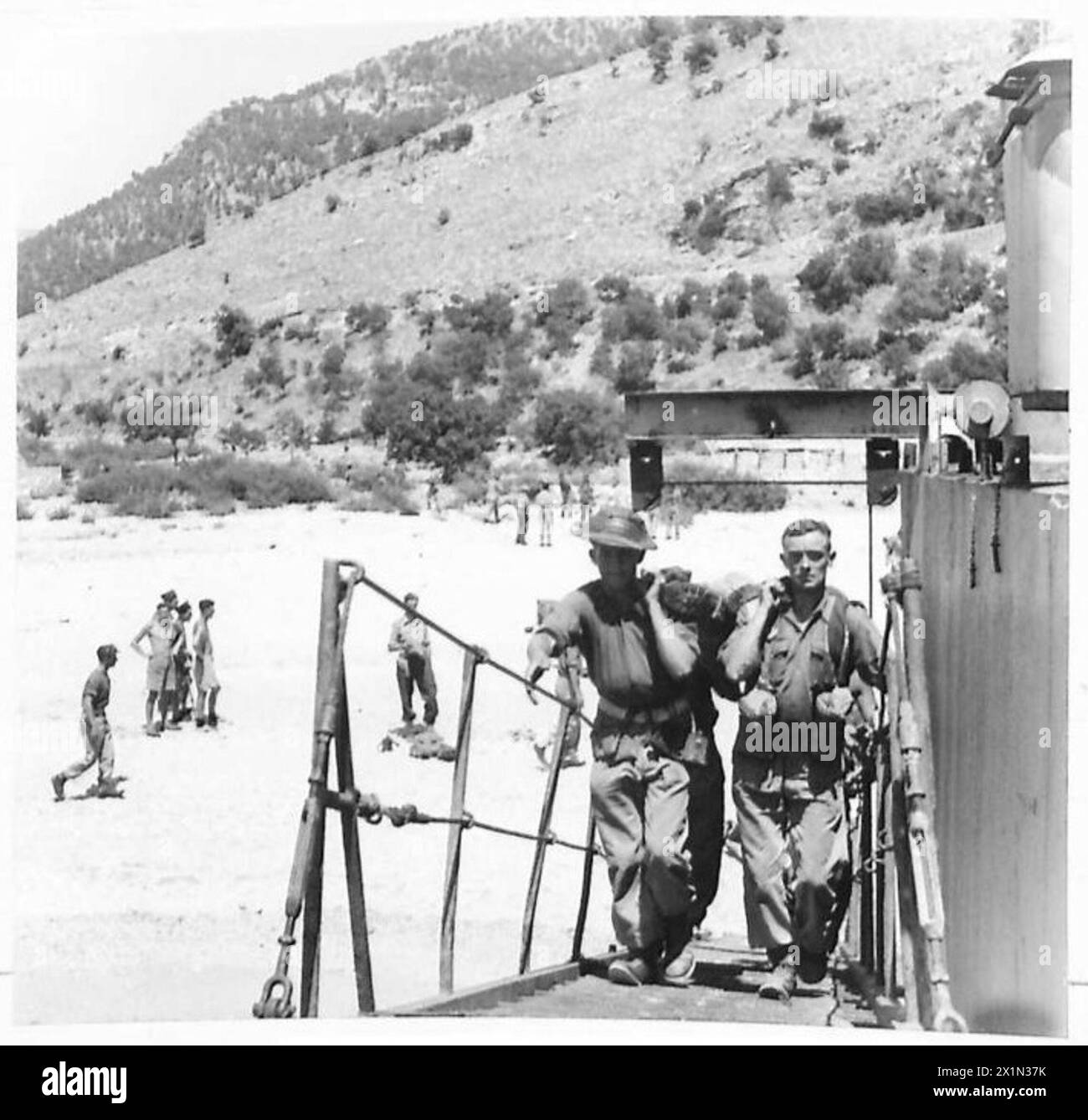 COMMANDOS RAID ALBANIA - A stretcher case is carried up the ramp into ...