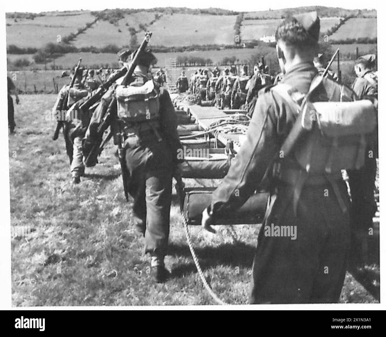 British Army infantrymen march with rifles to deploy a bridge, using ...