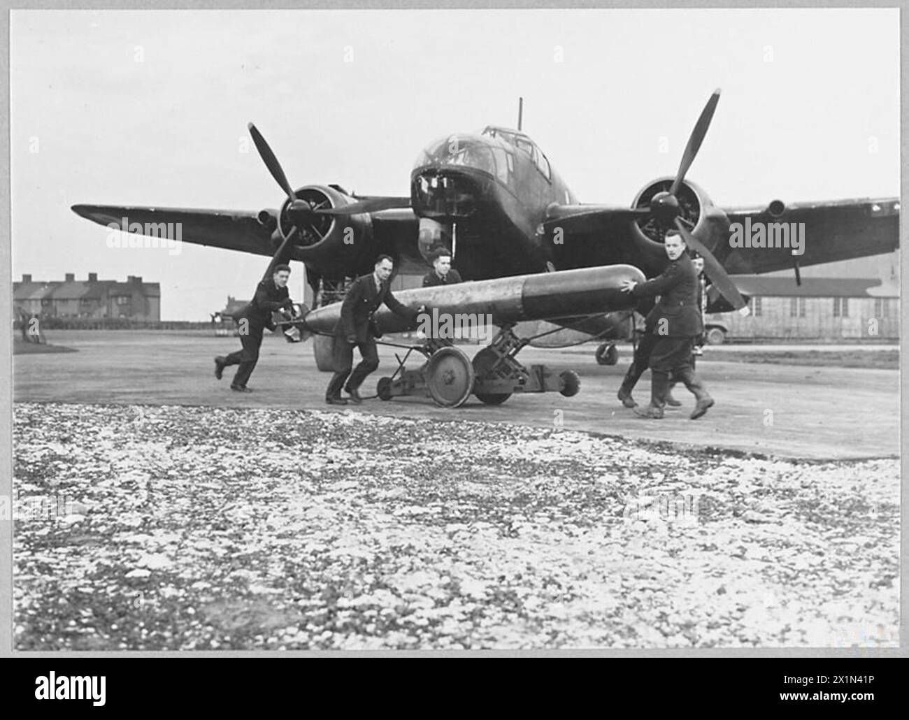 A torpedo is positioned to be loaded into the slings of an aircraft in ...