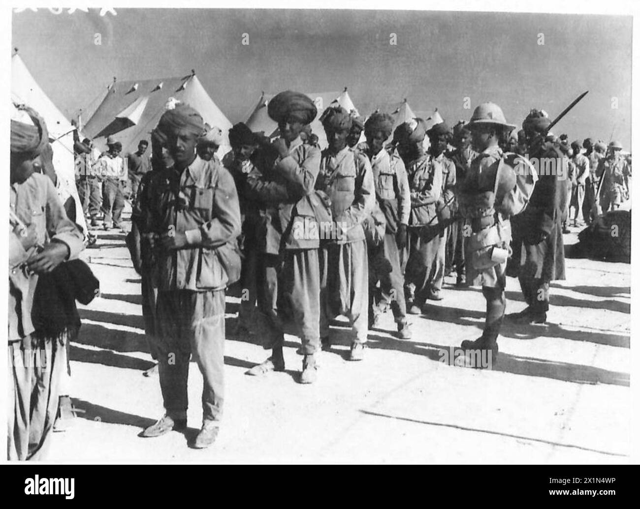An Italian prisoner of war is escorted by British Army personnel ...