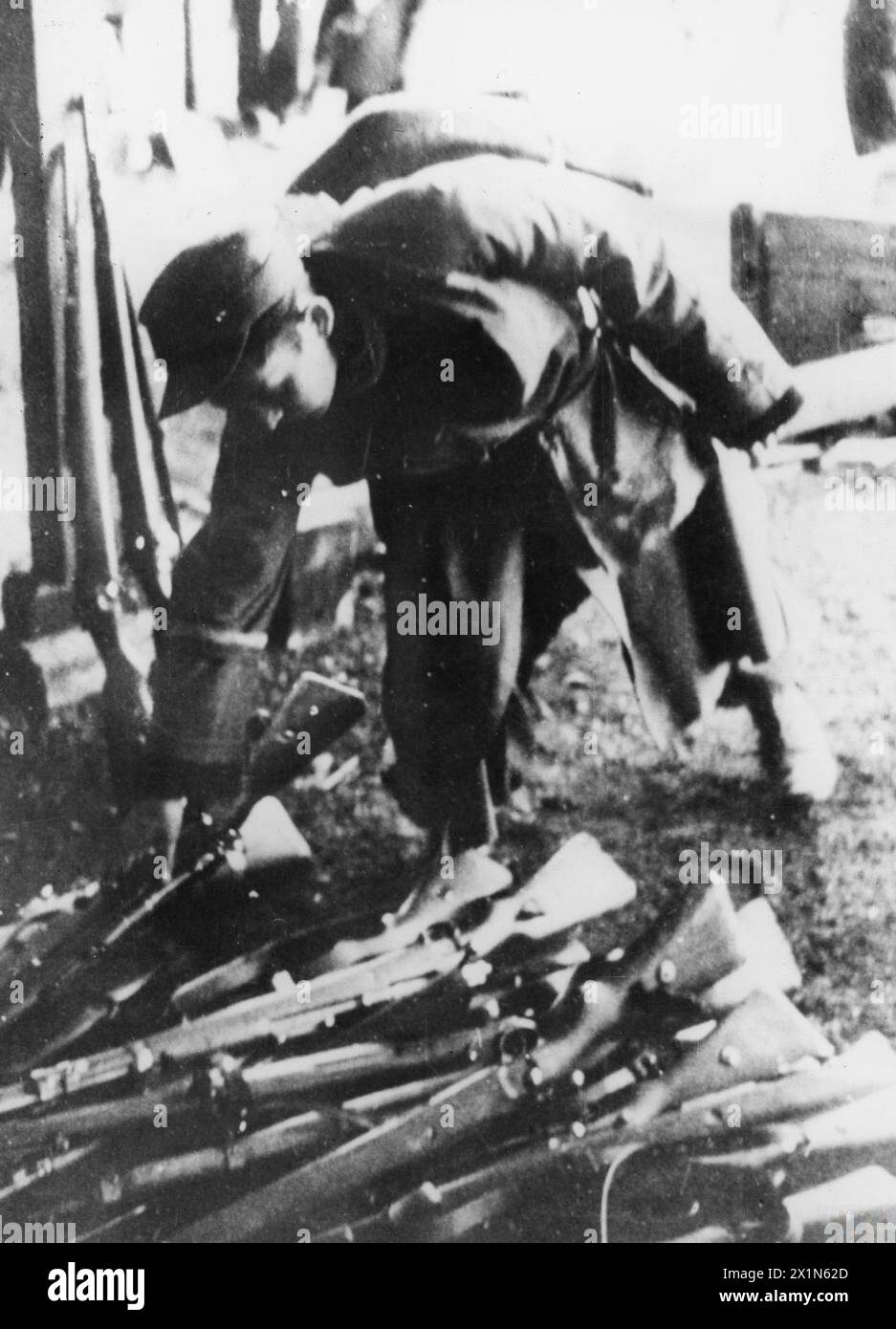 A soldier of the Home Army lays down his rifle following the surrender ...