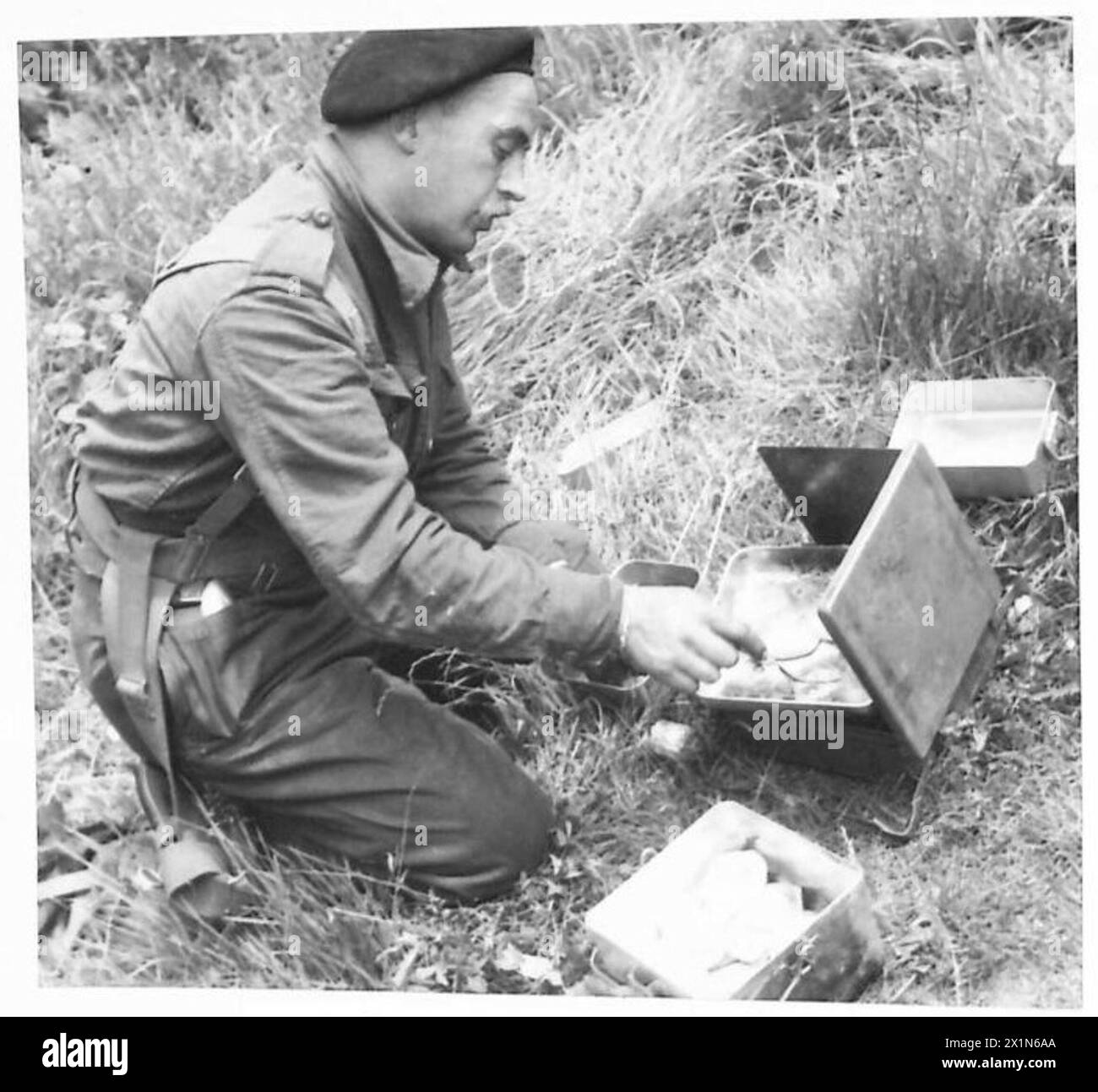 A tank crew member prepares breakfast during a mock invasion exercise ...