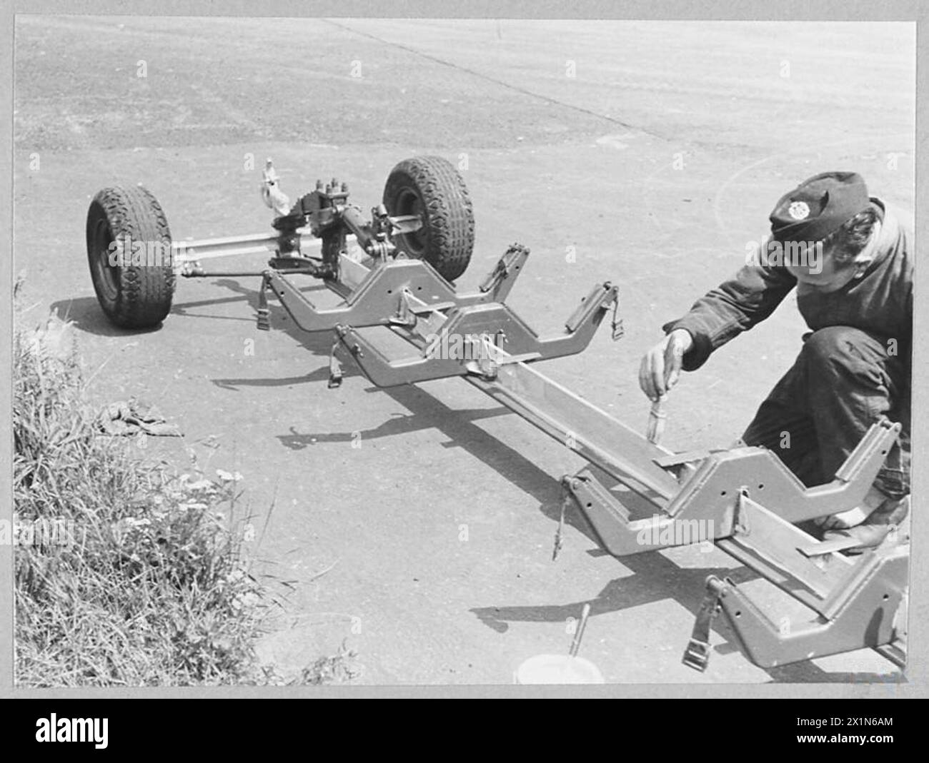 RAF ground staff paint and maintain a bomb carrier dolly while ...