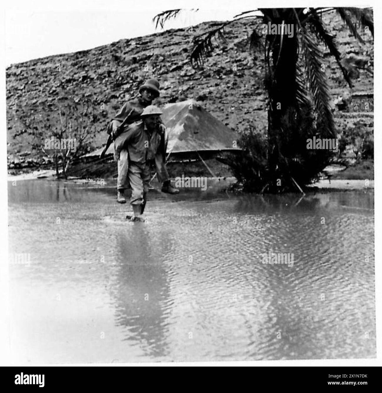 A soldier receives assistance after his tent was flooded, highlighting ...