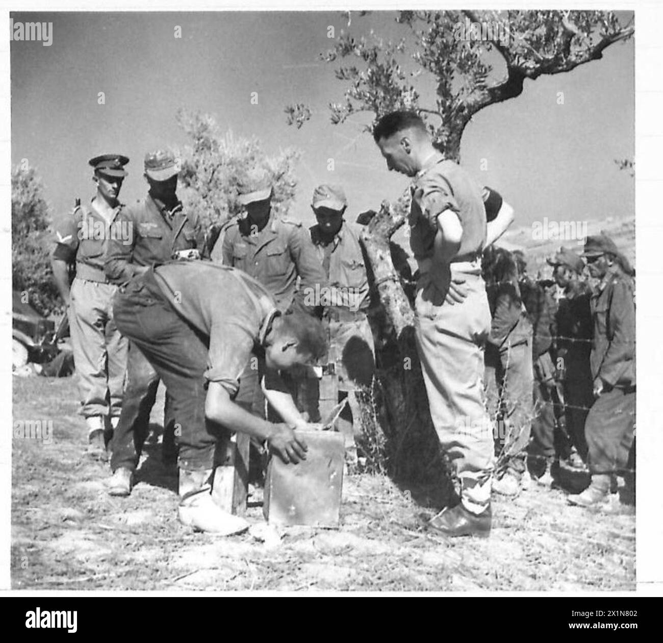 A German prisoner distributes food to fellow POWs under the supervision ...