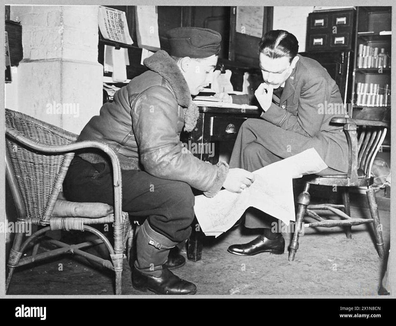 A Liberator navigator reports to intelligence officers after returning ...
