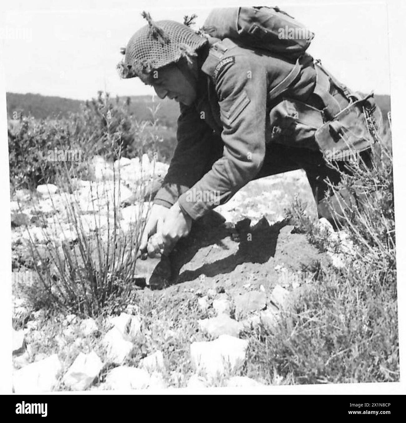 A Guardsman from the British Army fortifies a hillside position during ...