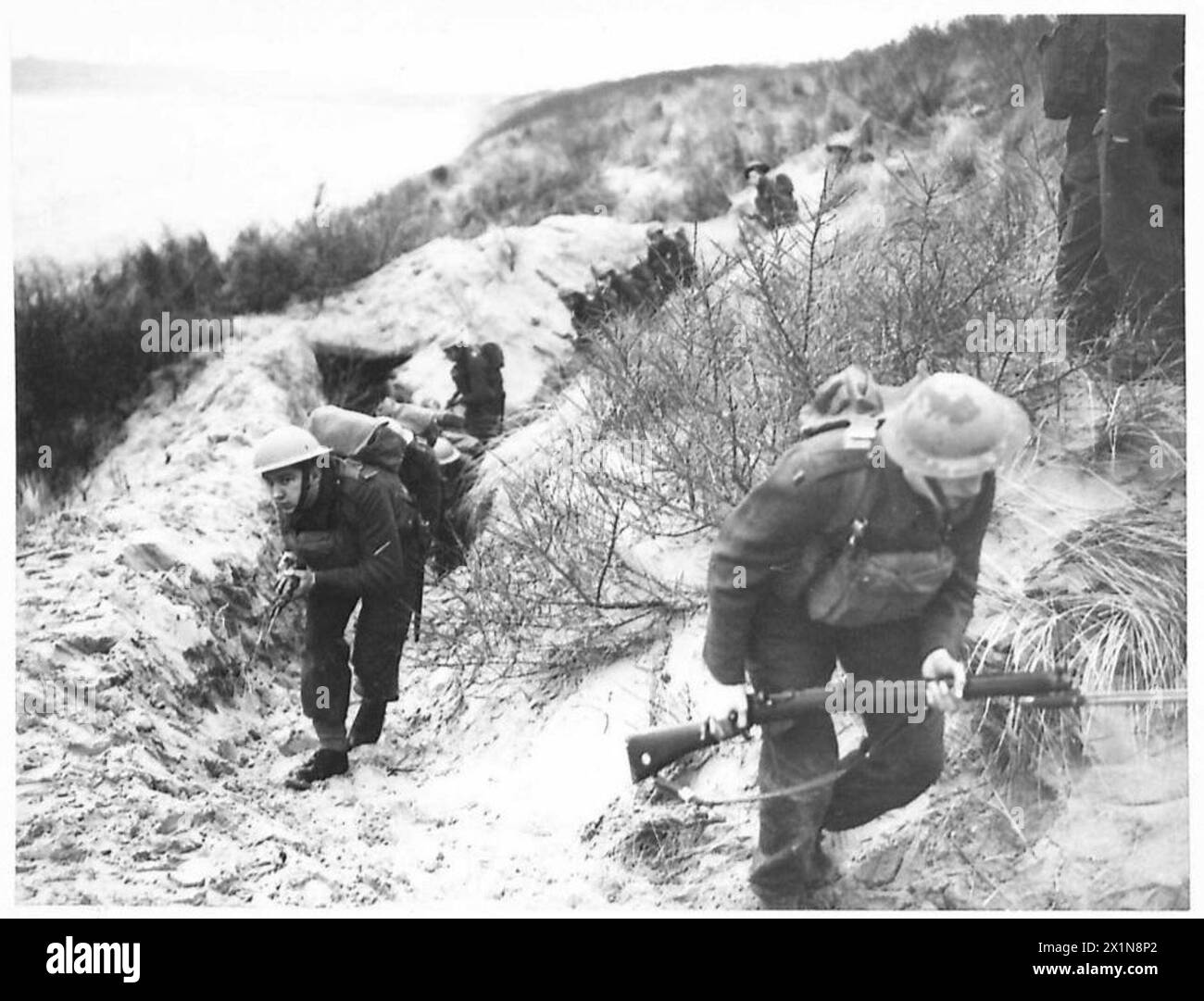 Belgian troops advance over a seashore trench during training exercises ...