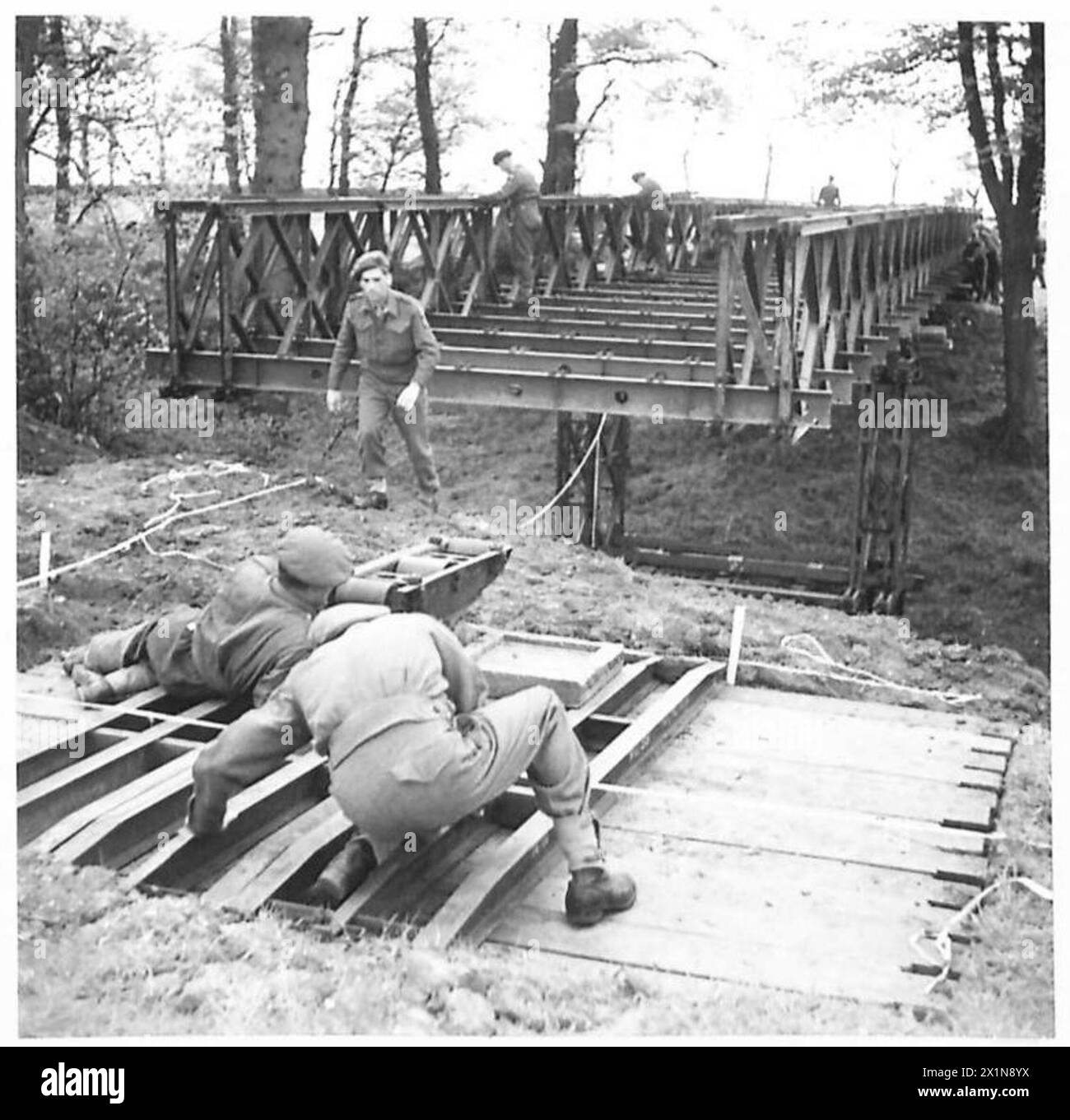 ERECTING A BAILEY BRIDGE - Bridge nearing the touch down position over ...