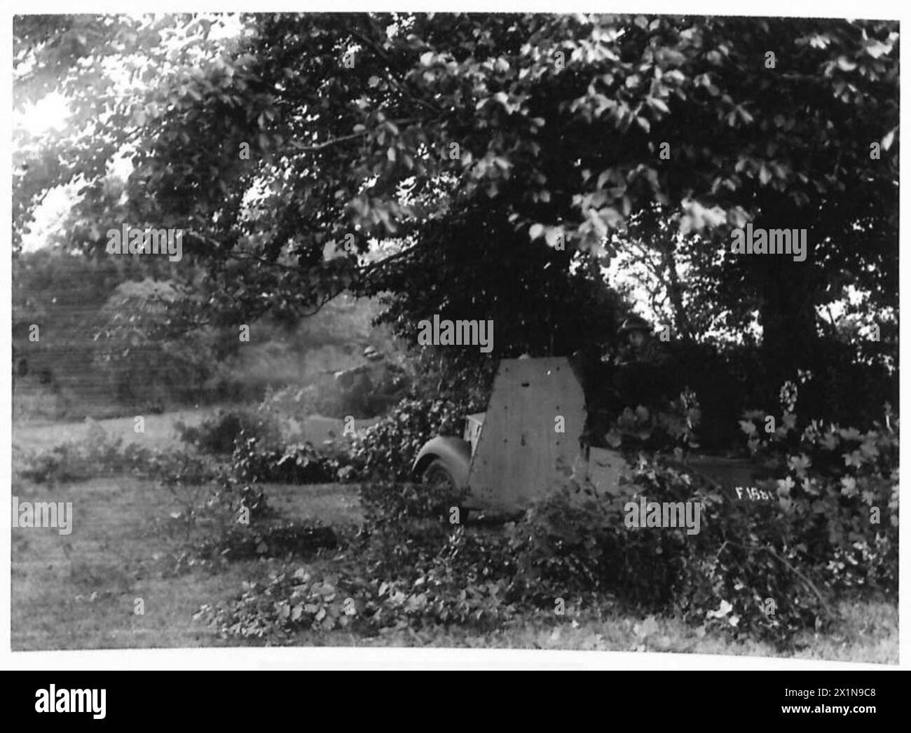 Armoured car crews camouflage vehicles using branches, illustrating ...