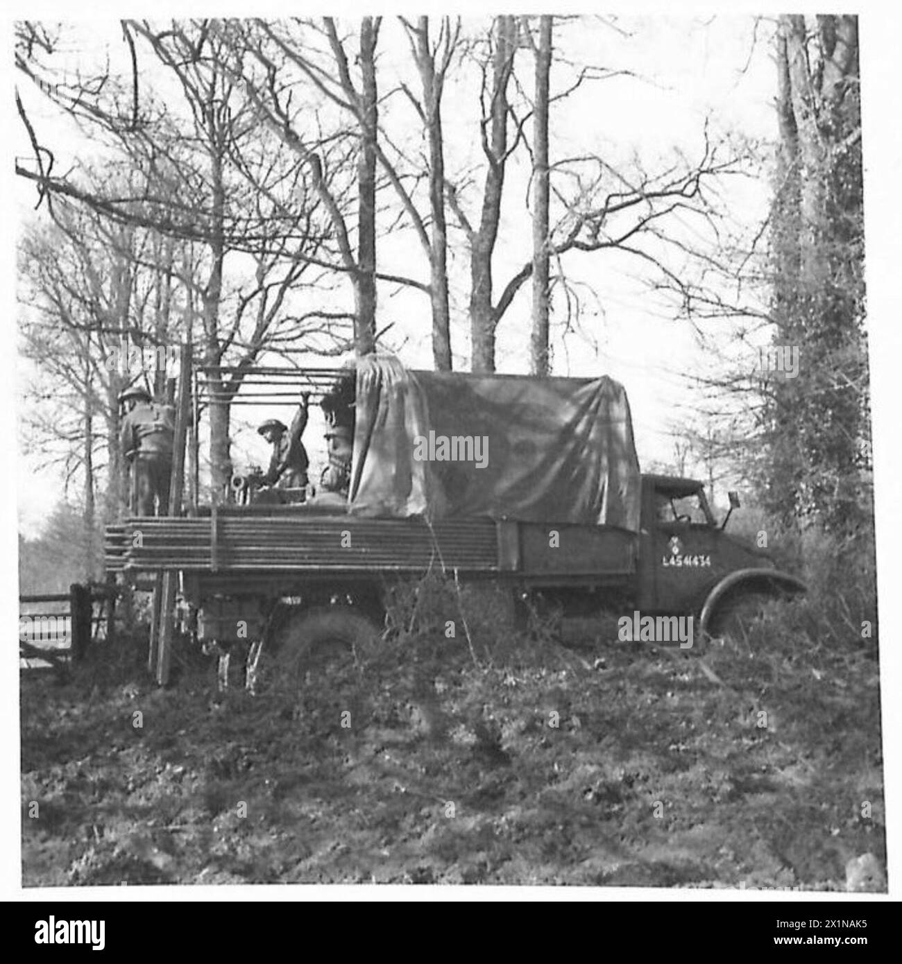 Signal personnel operate a mechanical cable layer from a lorry during ...