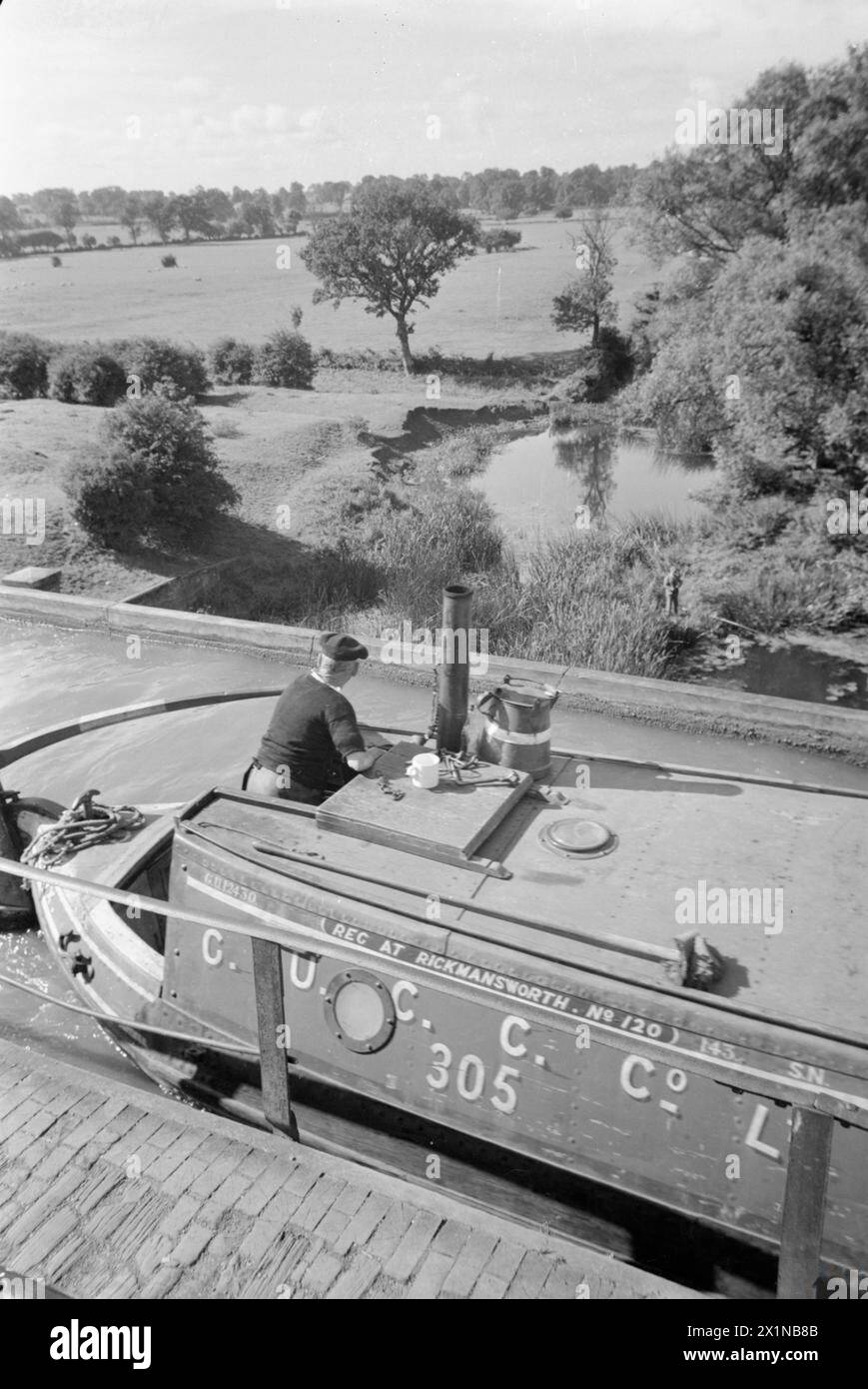 A Rickmansworth-registered canal boat crosses the Grand Union Canal ...