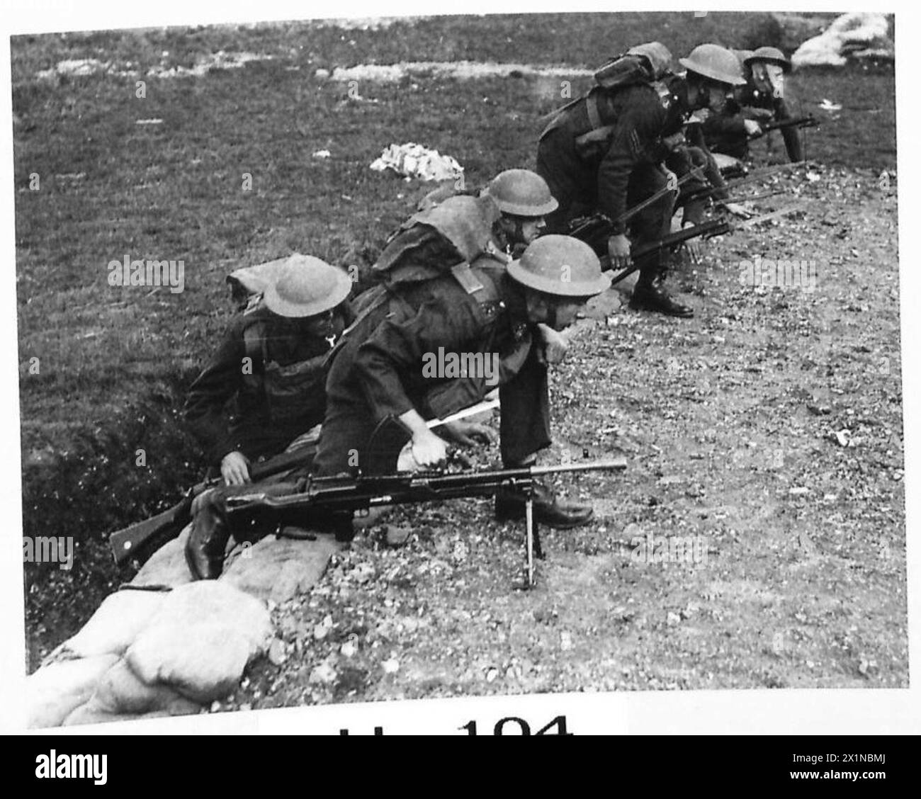Soldiers of the British Army practice firing rifles and Bren guns from ...