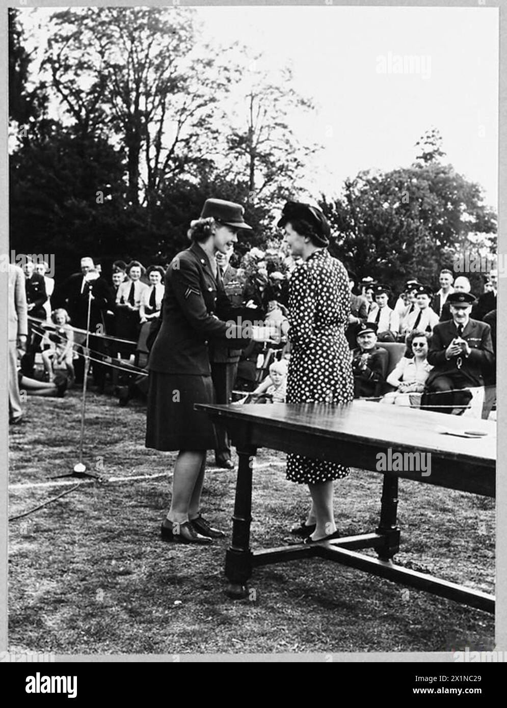 Lady Leigh-Mallory is presented with a bouquet by a WAAF corporal at a ...