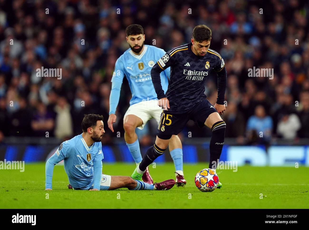 Real Madrid's Federico Valverde (right) is challenged by Manchester ...