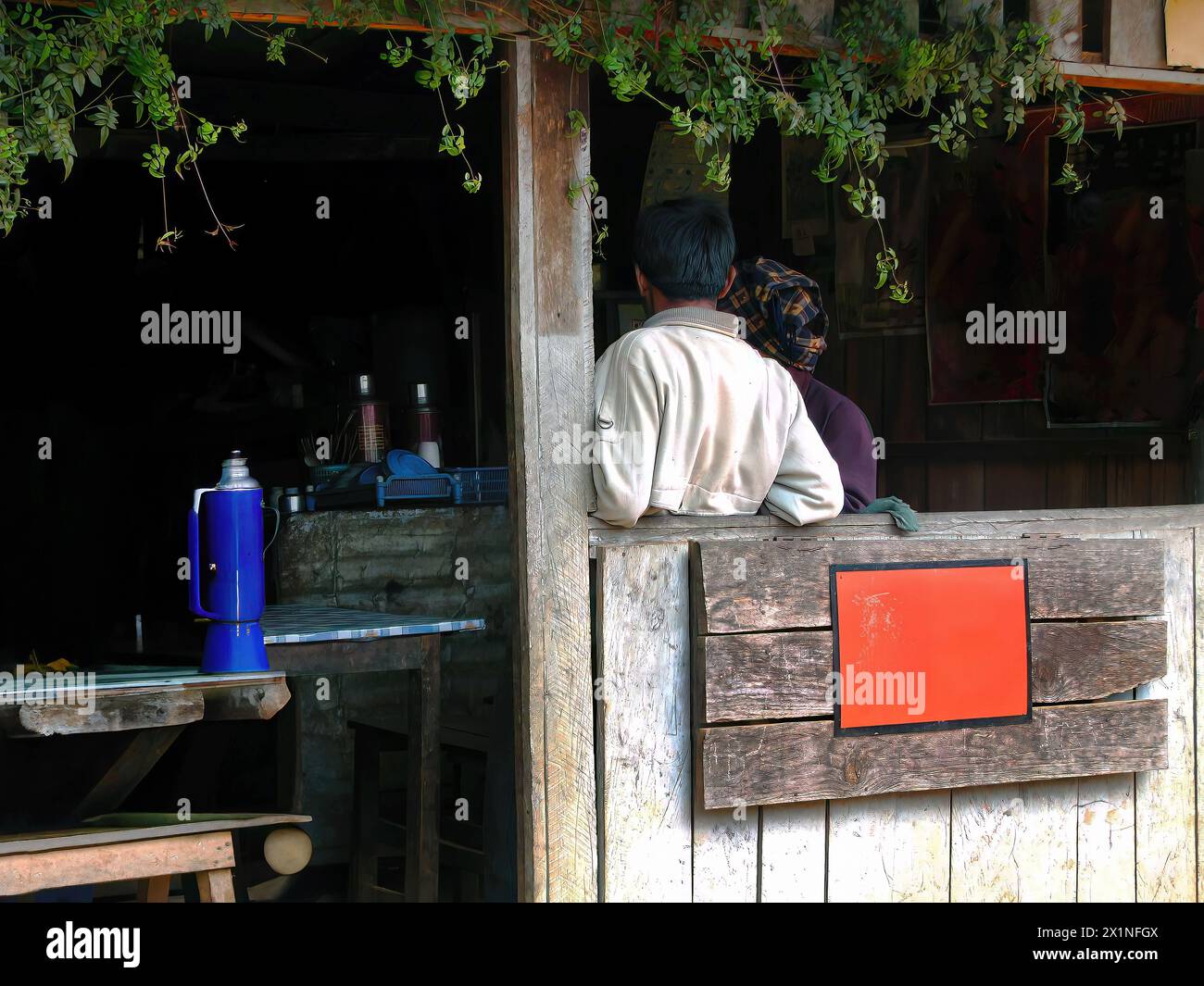 Backside of two local people standing in their tradition food shack ...