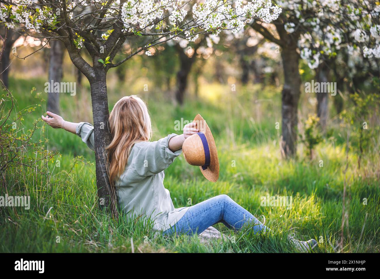 Happy woman with straw hat enjoying fresh air and sunlight in spring ...
