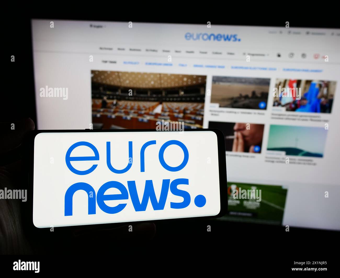 Person holding smartphone with logo of Belgian television news network ...