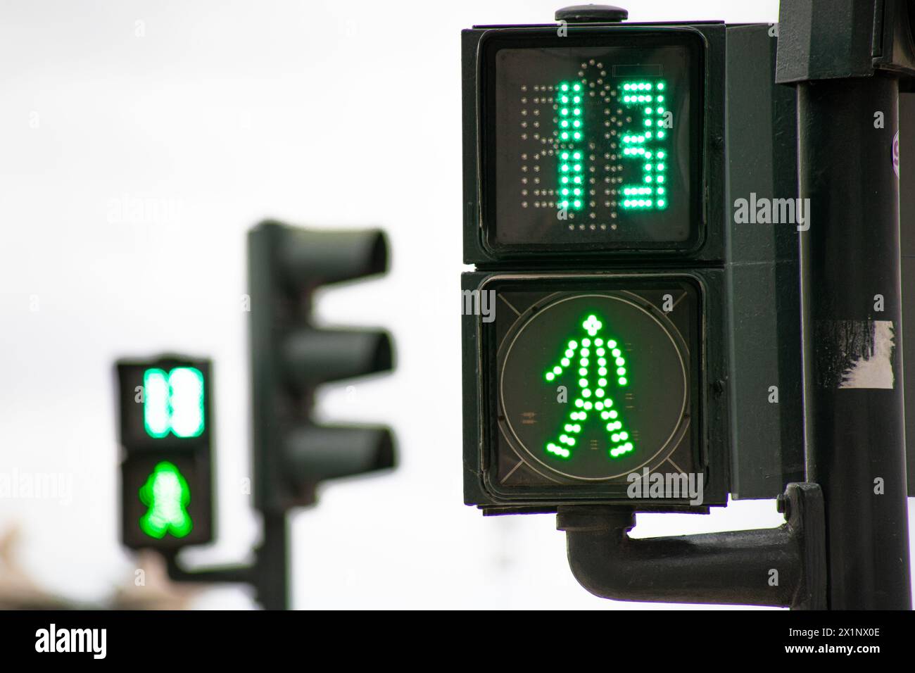 Green traffic light for pedestrians counting down in 13 seconds in ...