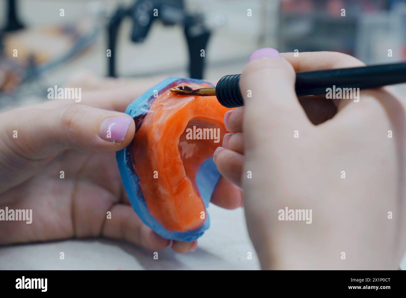 The dental technician makes a wax base and adds wax to form the mold ...