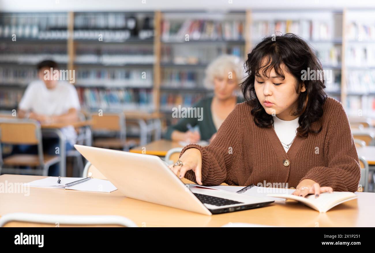 Fifteen-old-year schoolgirl doing homework in the school library Stock ...