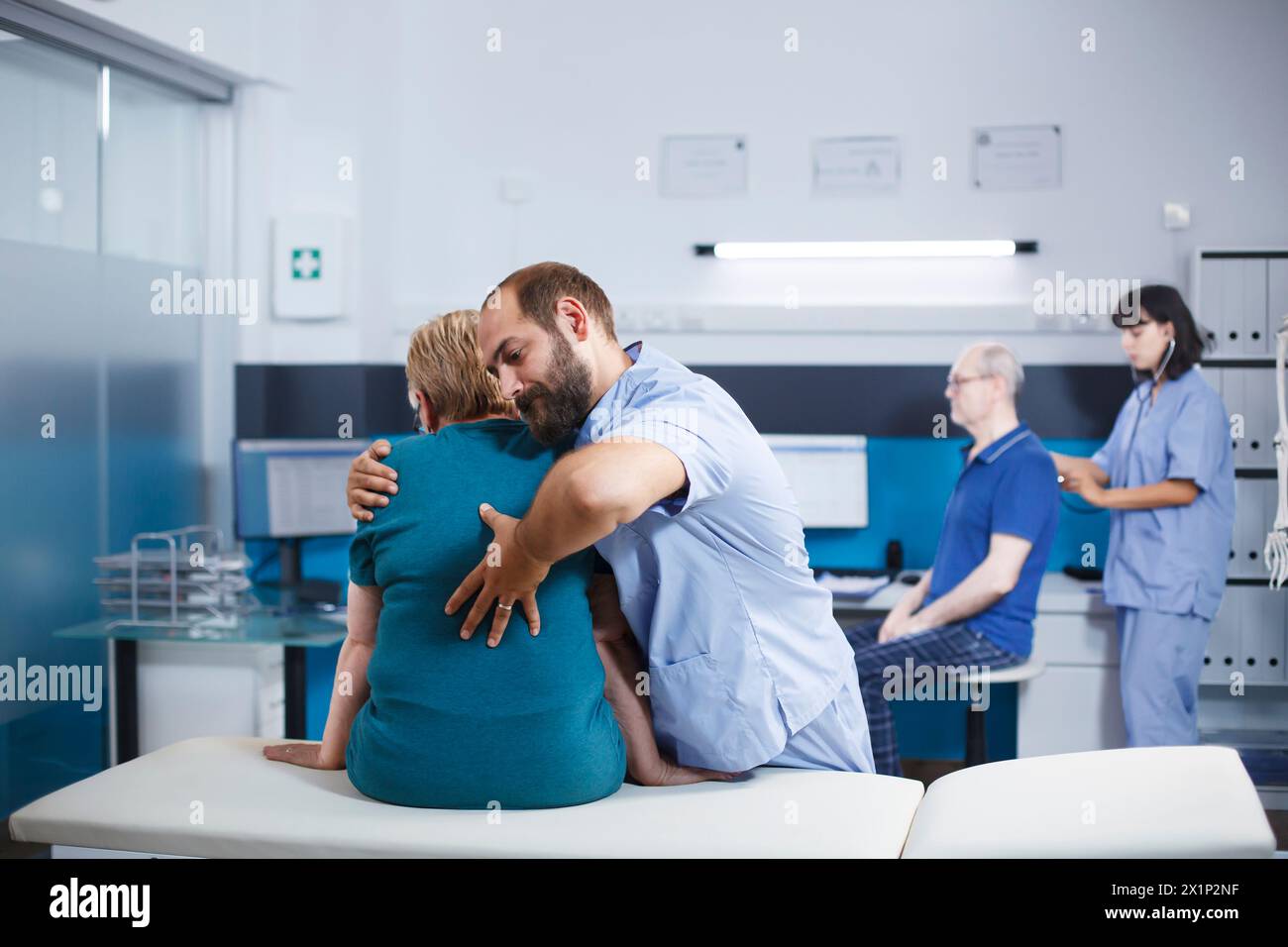 Nurse in blue scrubs treating old woman with back and spine pain for ...