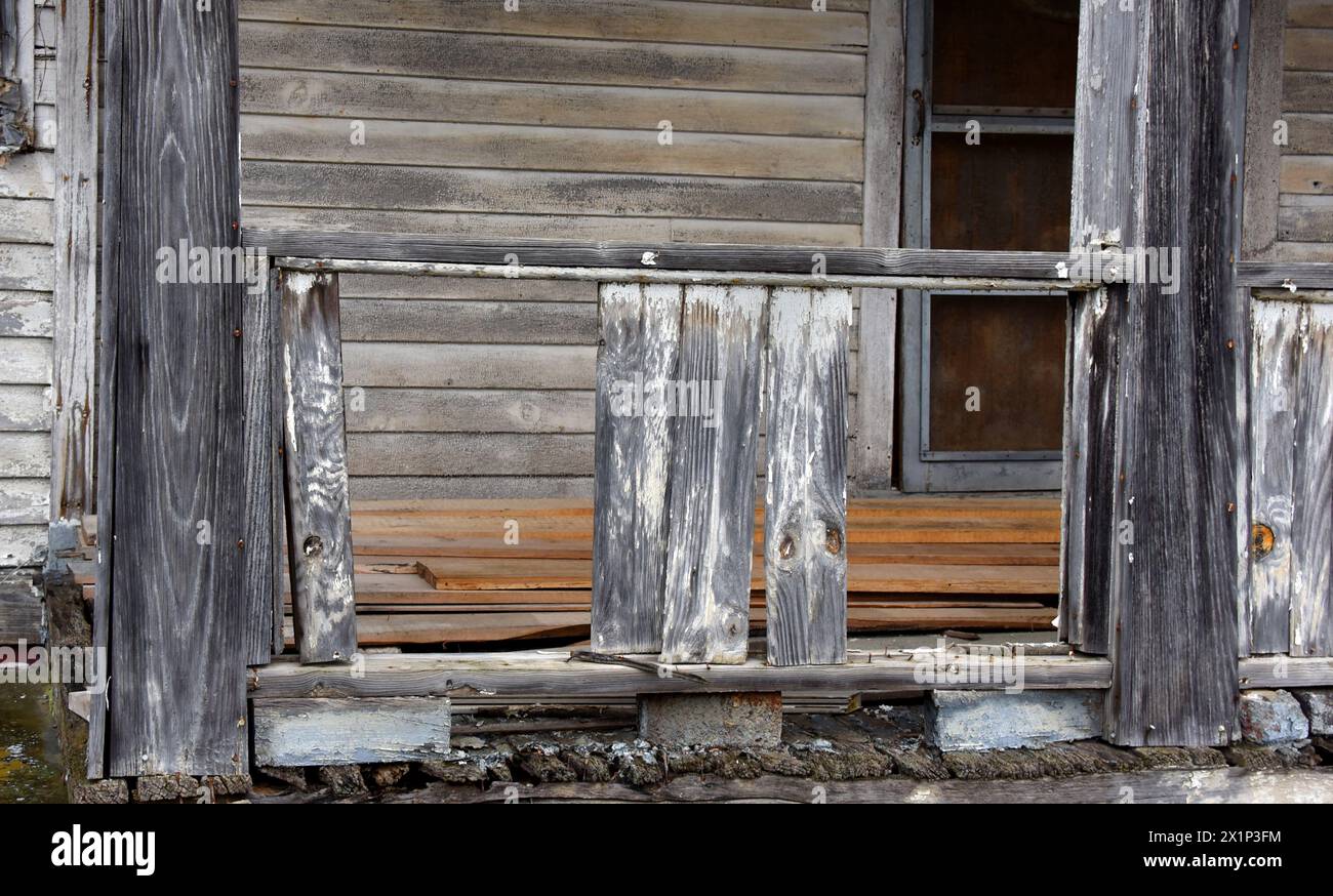 Ruins of an old house shows front porch broken and rotting. Wooden ...