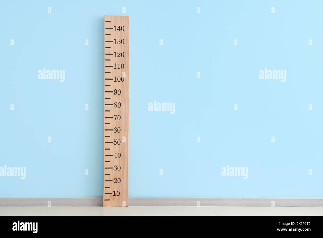 Wooden stadiometer near blue wall Stock Photo - Alamy