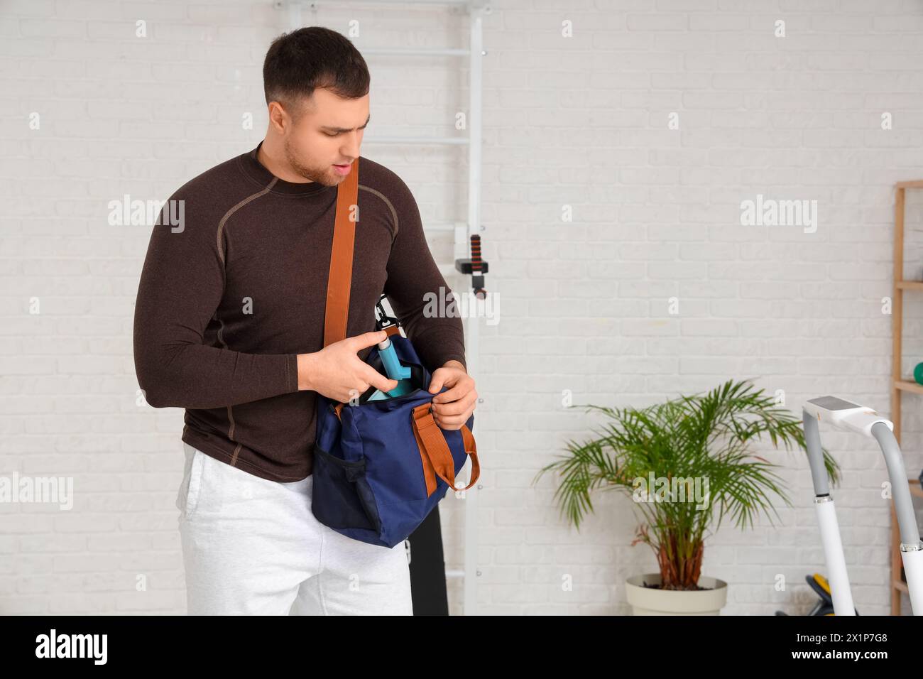 Sporty young man taking inhaler from bag in gym Stock Photo - Alamy