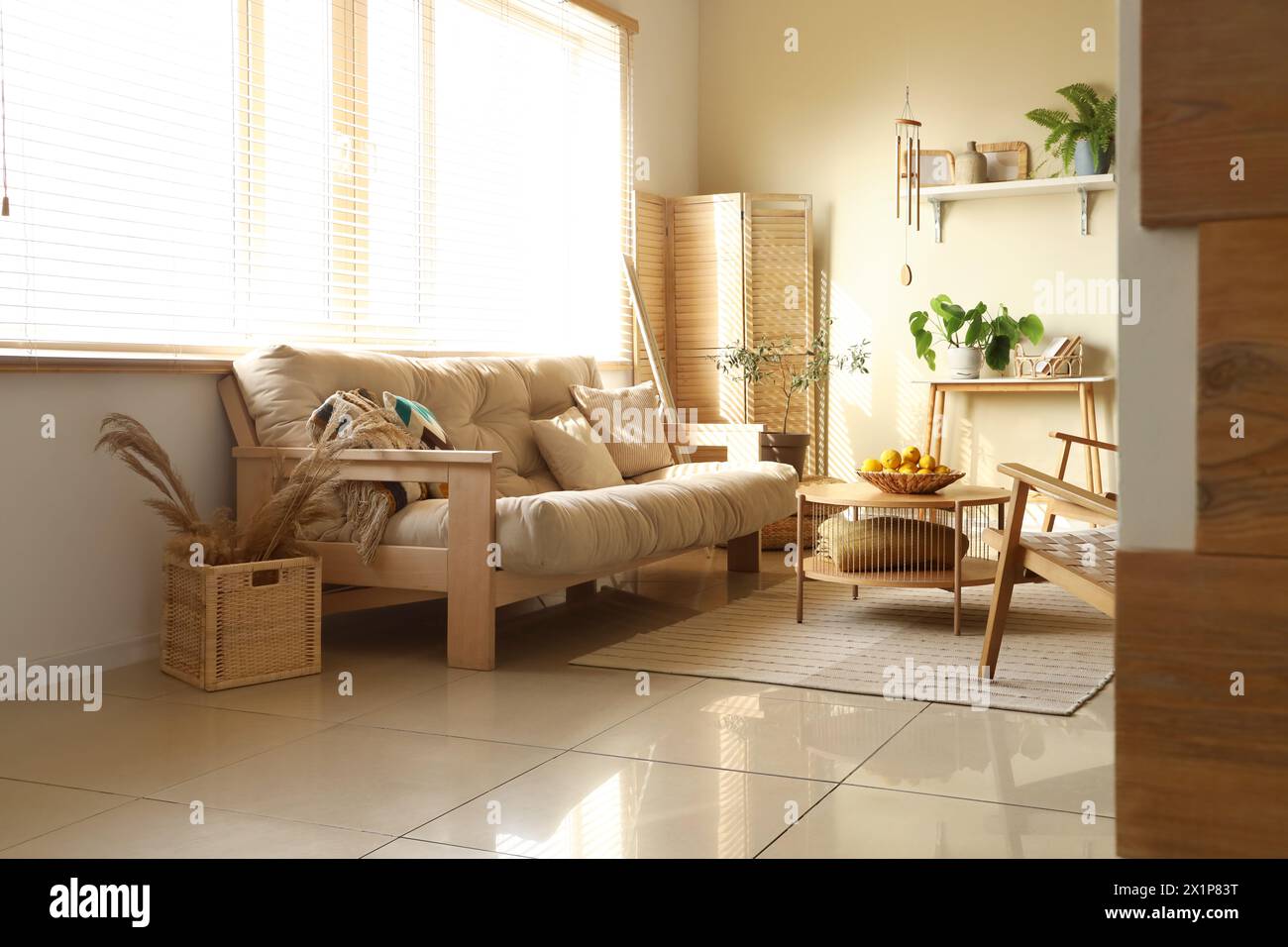 Interior of light living room with wind chime, sofa and table Stock ...