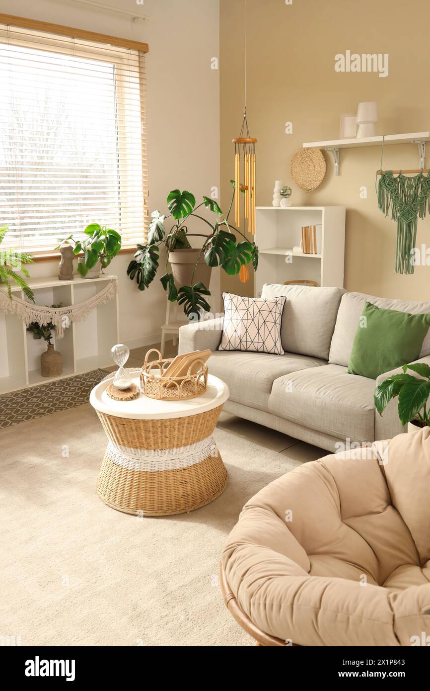 Interior of light living room with wind chime, sofa and plants Stock ...
