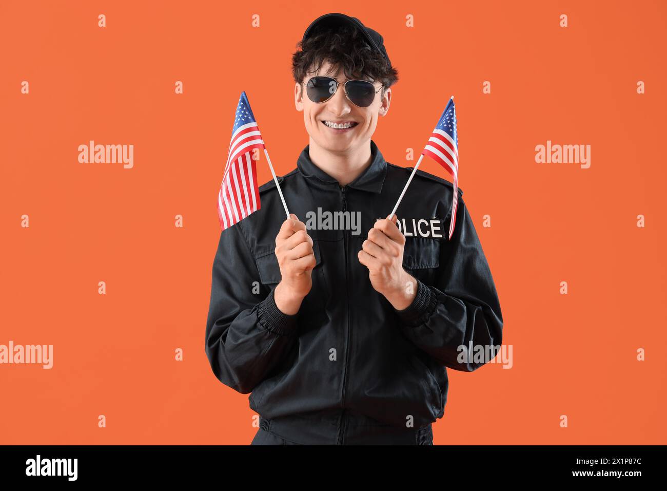 Male police officer with USA flags on orange background Stock Photo - Alamy