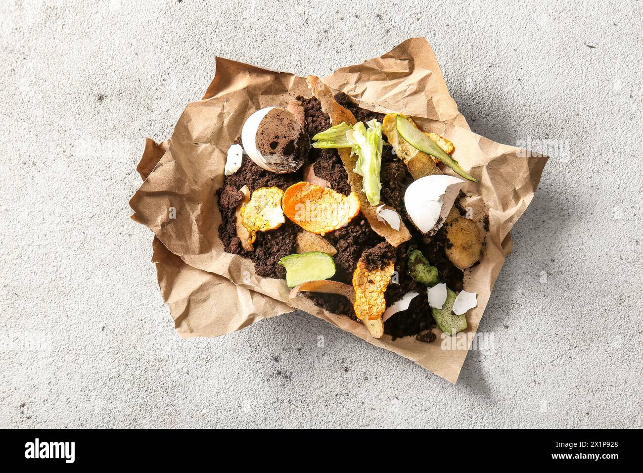 Paper with organic waste and soil on white grunge background. Compost ...