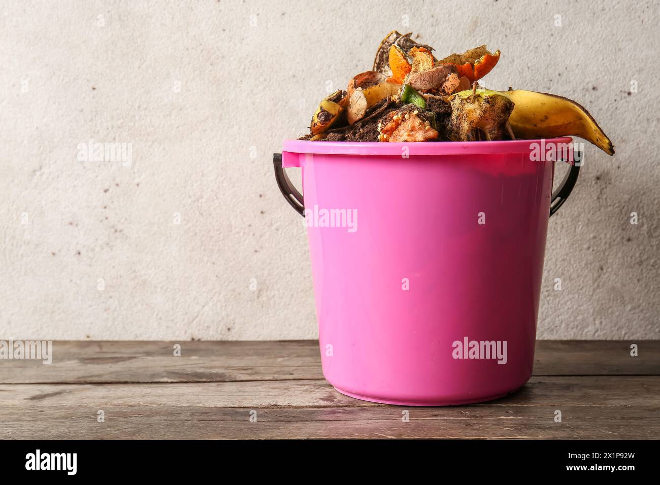 Bucket with organic waste and soil on wooden table. Compost recycling ...
