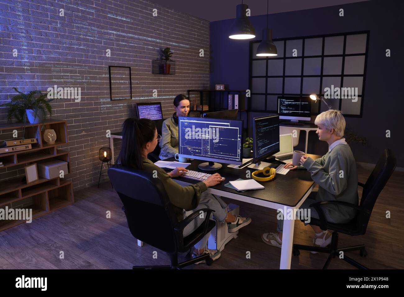 Group of female programmers working in office at night Stock Photo - Alamy