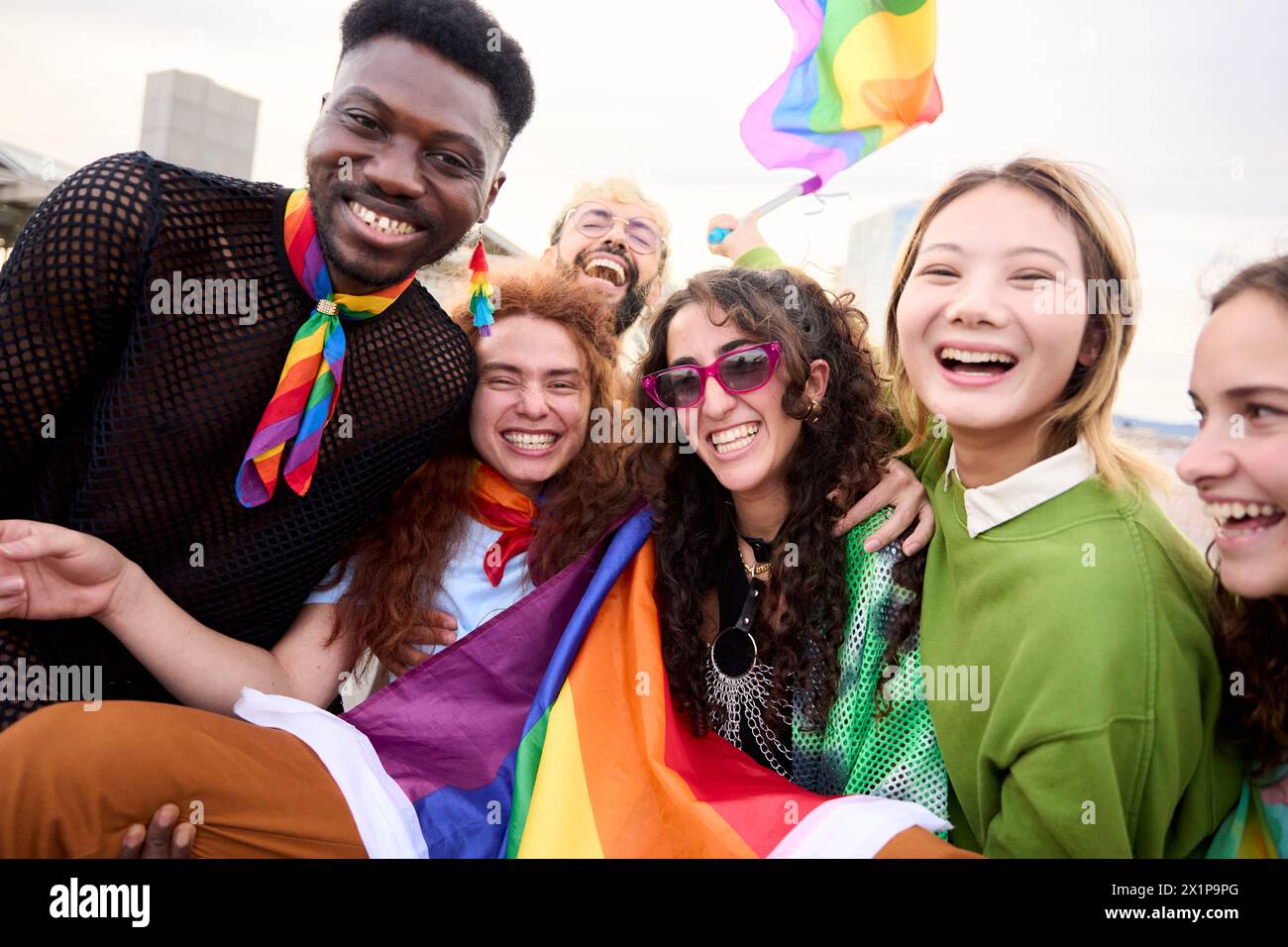 Happy group posing with rainbow flag for a fun event Stock Photo - Alamy