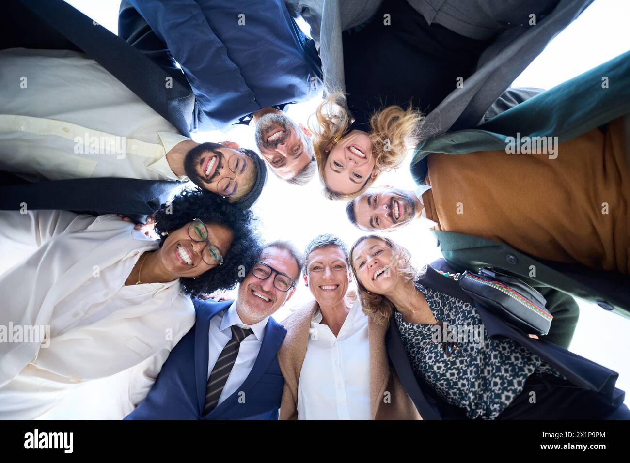 A group of diverse business people in formal wear gathered in a circle ...