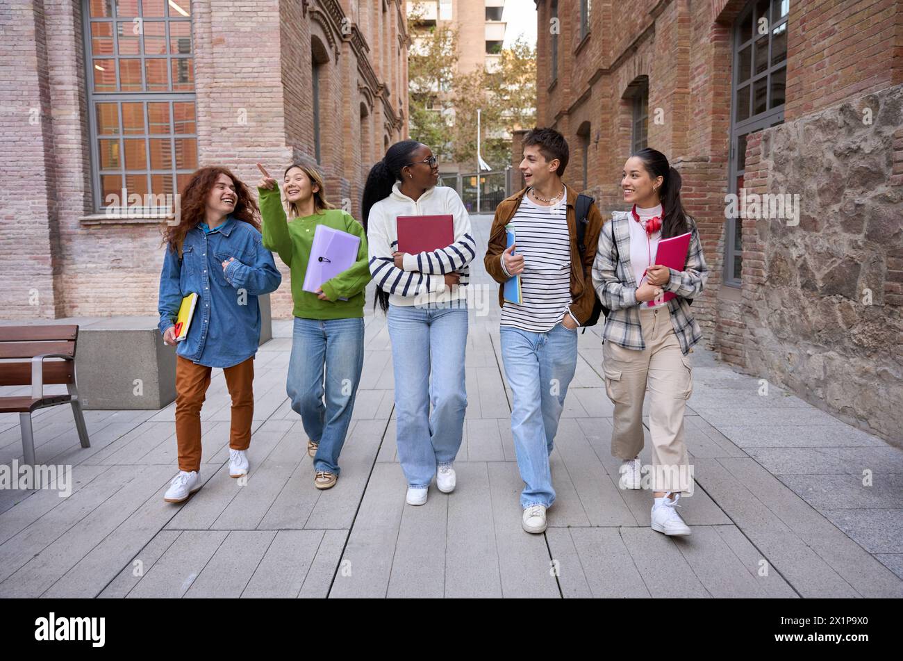 Happy students strolling around the university campus with workbooks and drinking coffee Stock ...