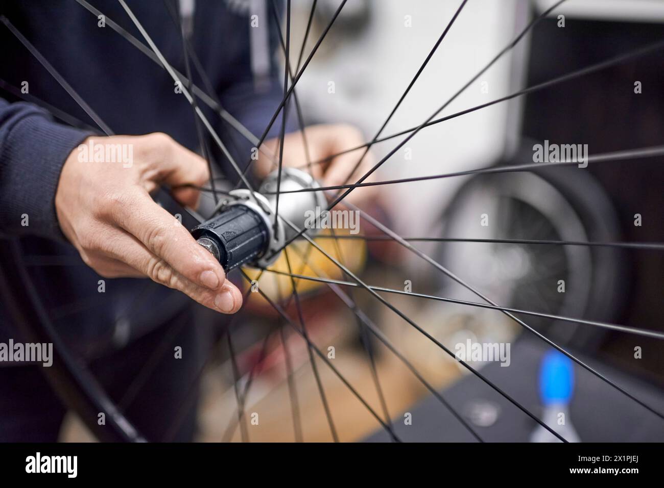 Unrecognizable man assembling a bike wheel axle after disassembling it ...