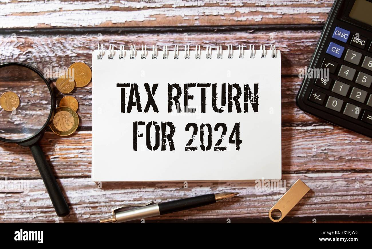 Green notepad on financial documentation. Text TAX FORM 2024. Business ...