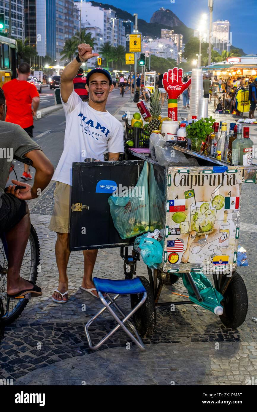 A Man Sells Alcoholic Drinks From A Trolley/Cart On Copacabana Beach ...